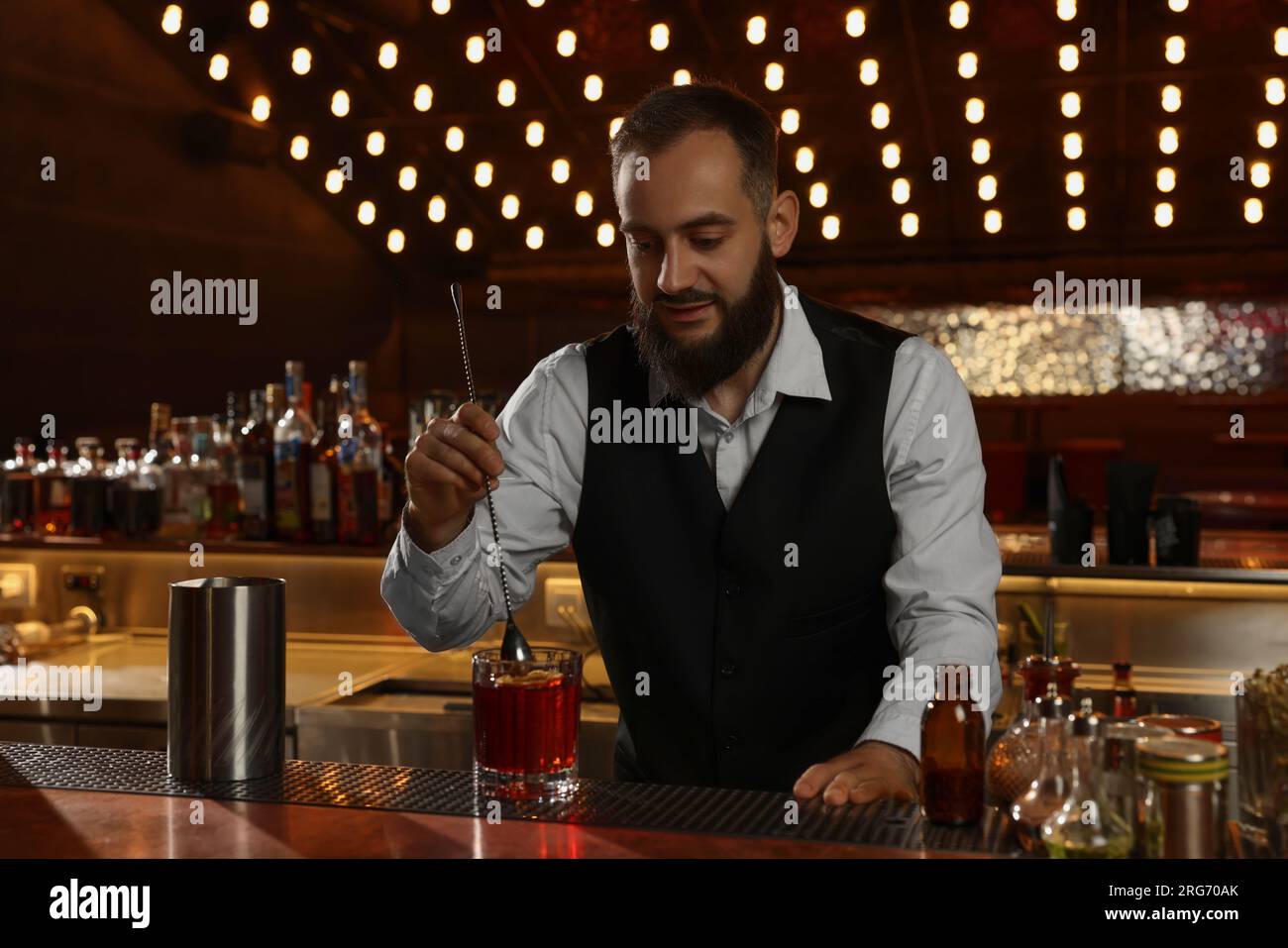 Bartender making fresh alcoholic cocktail at bar counter Stock Photo ...