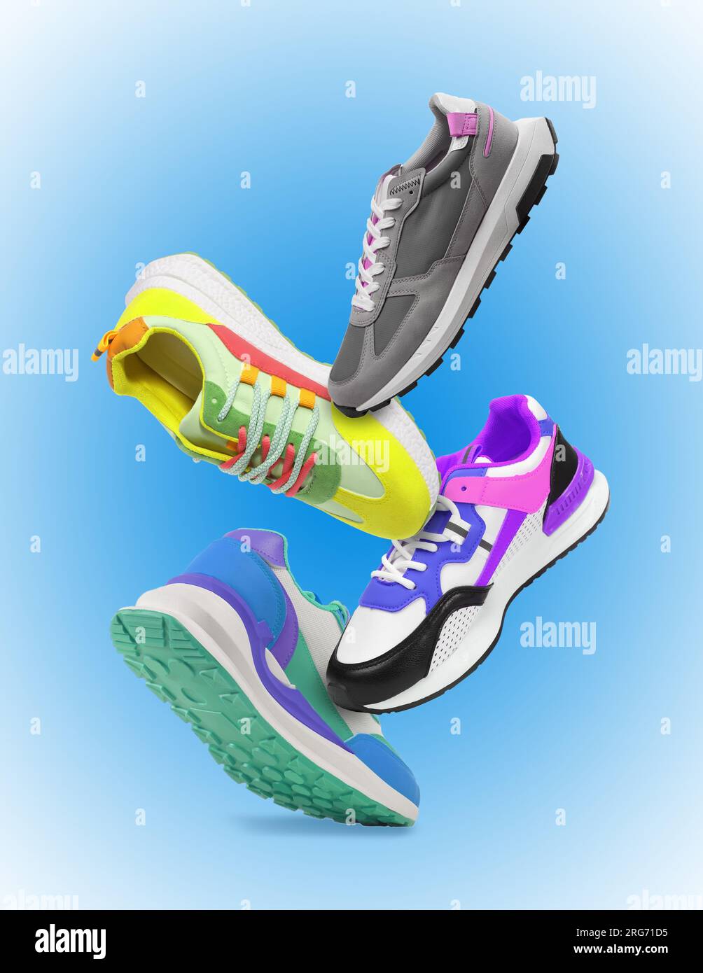 Different sneakers falling on blue gradient background Stock Photo - Alamy