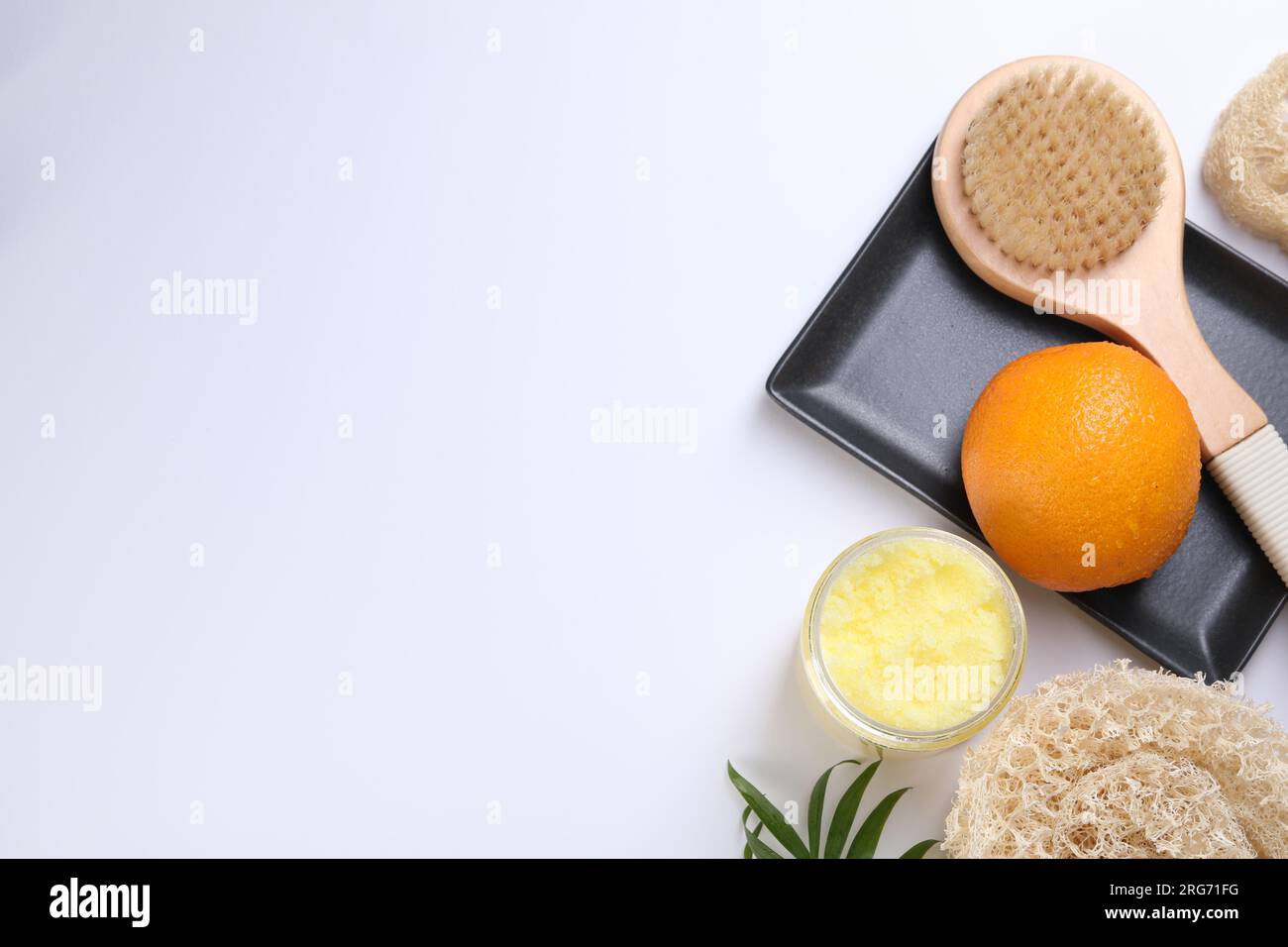 Orange, scrub and brush on white background, flat lay with space for ...