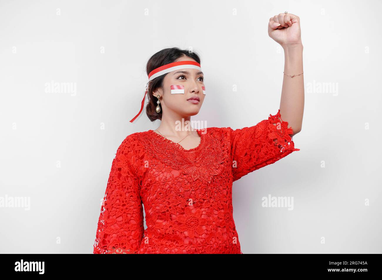 Young woman speaker wearing red kebaya and headband gesturing oration ...