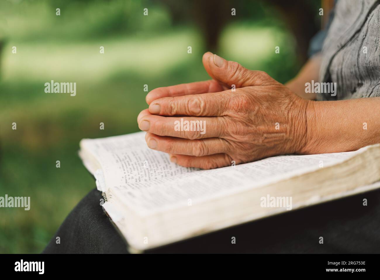 Old woman praying for hope or reading holy bible Stock Photo - Alamy