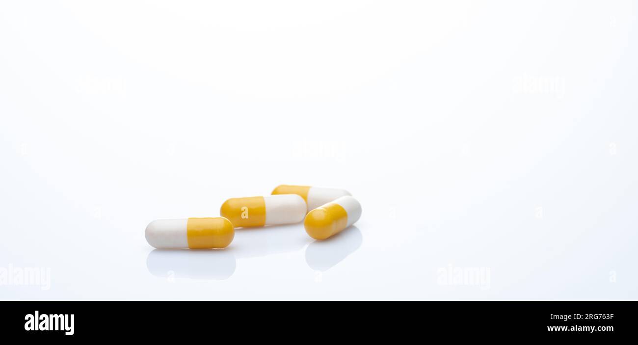 Yellow-white probiotic capsule pill on white background. Probiotic ...