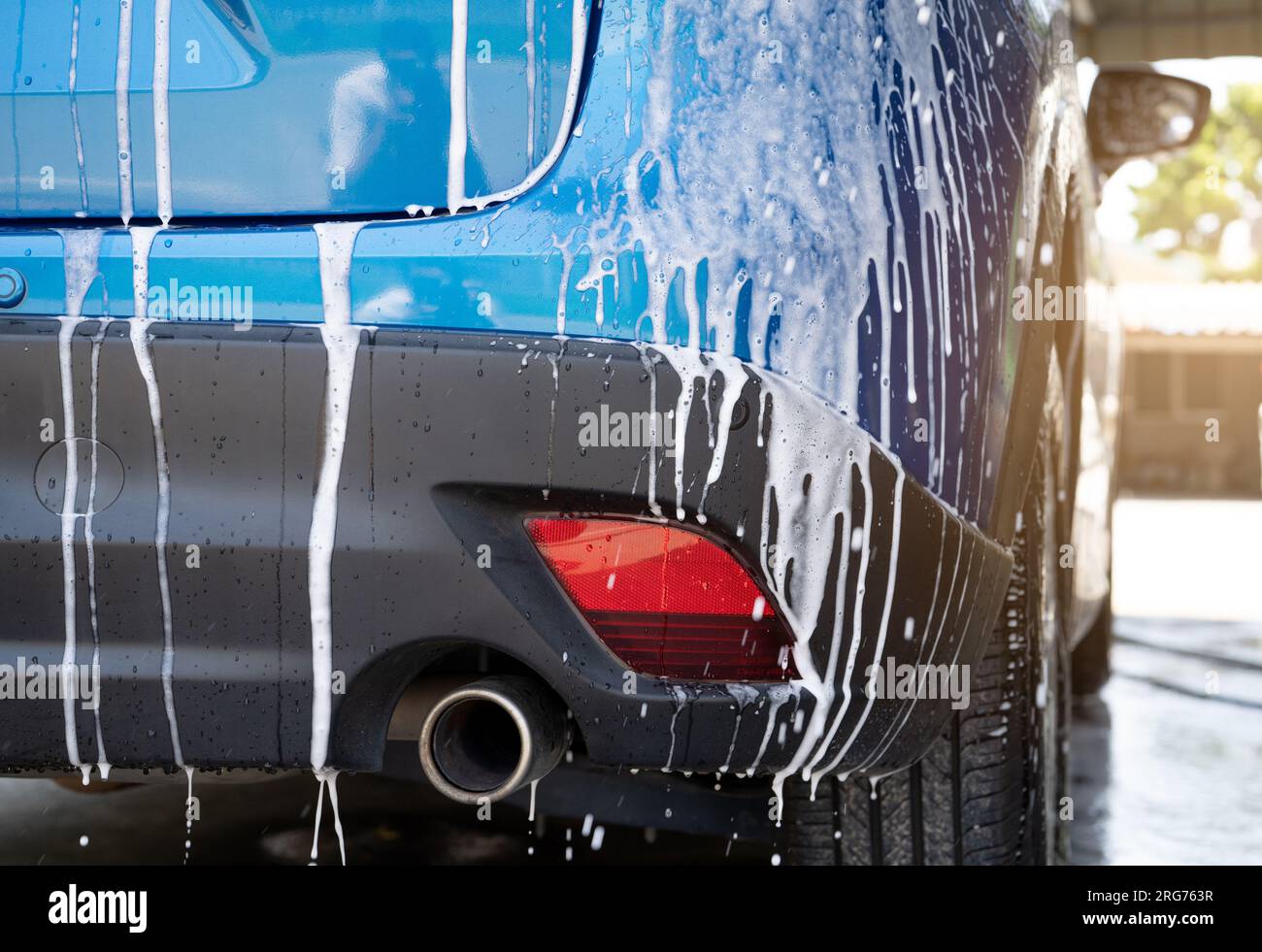 Blue car wash with white soap foam and professional auto care service ...