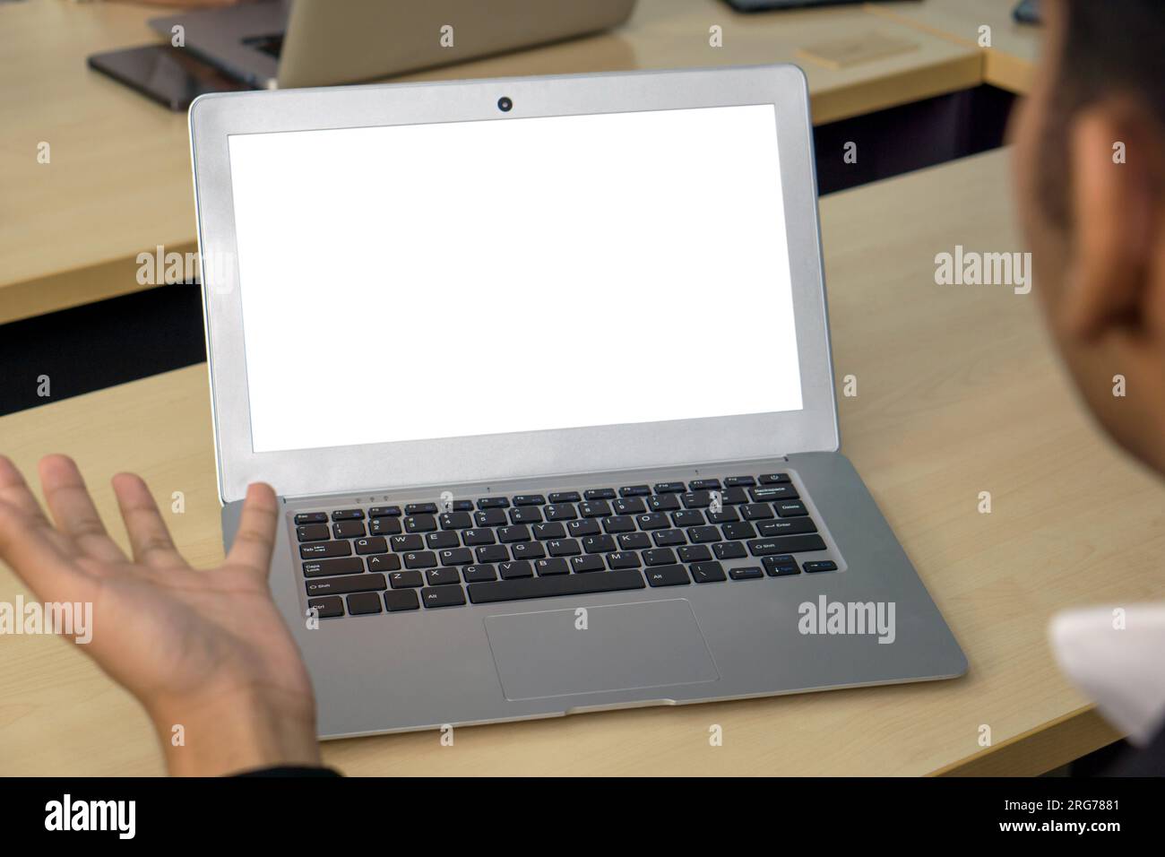 A male person intently focused on a meeting with a blank white screen ...