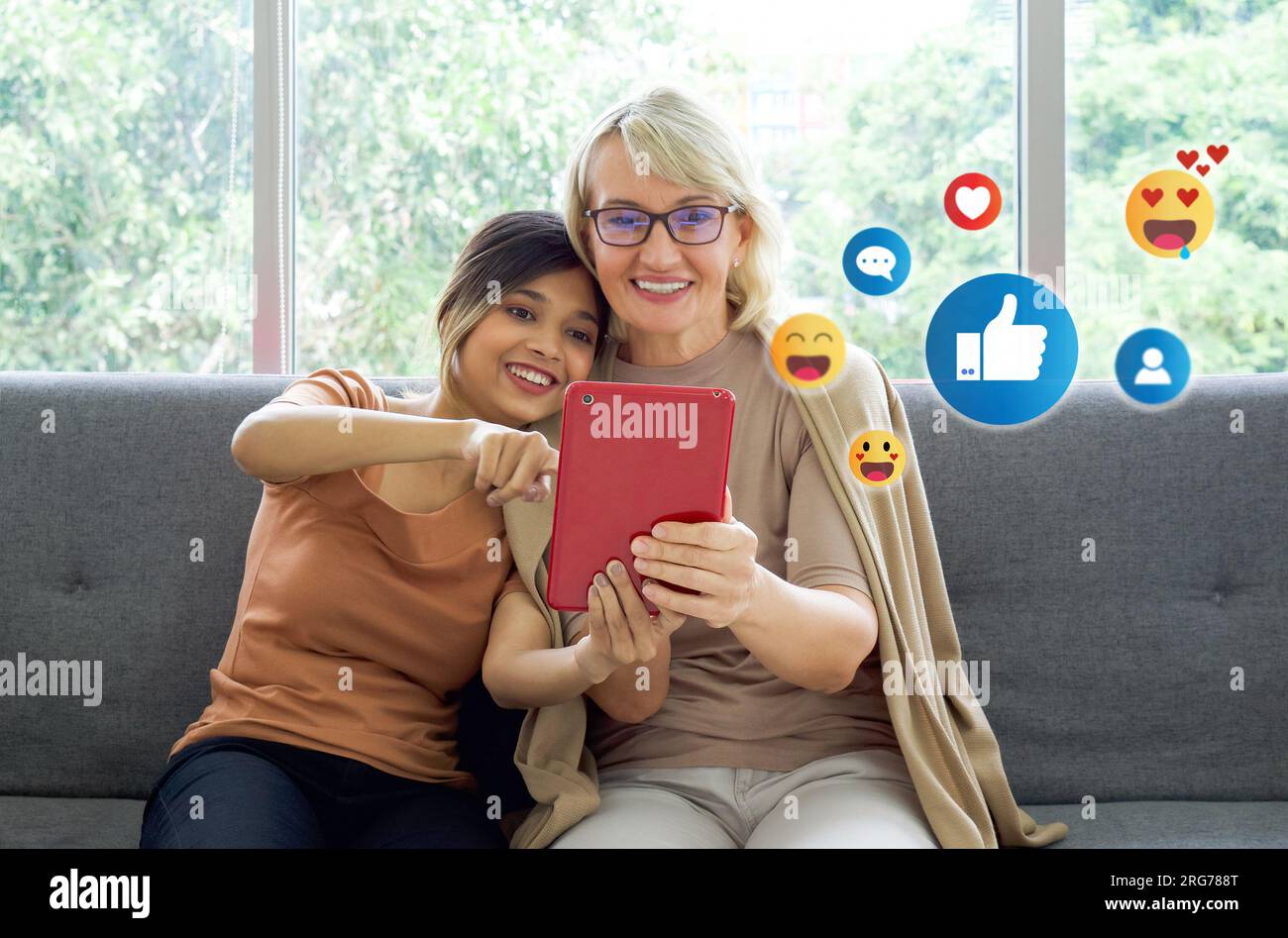 A candid image of two women comfortably seated on a couch, attentively browsing social media on ...
