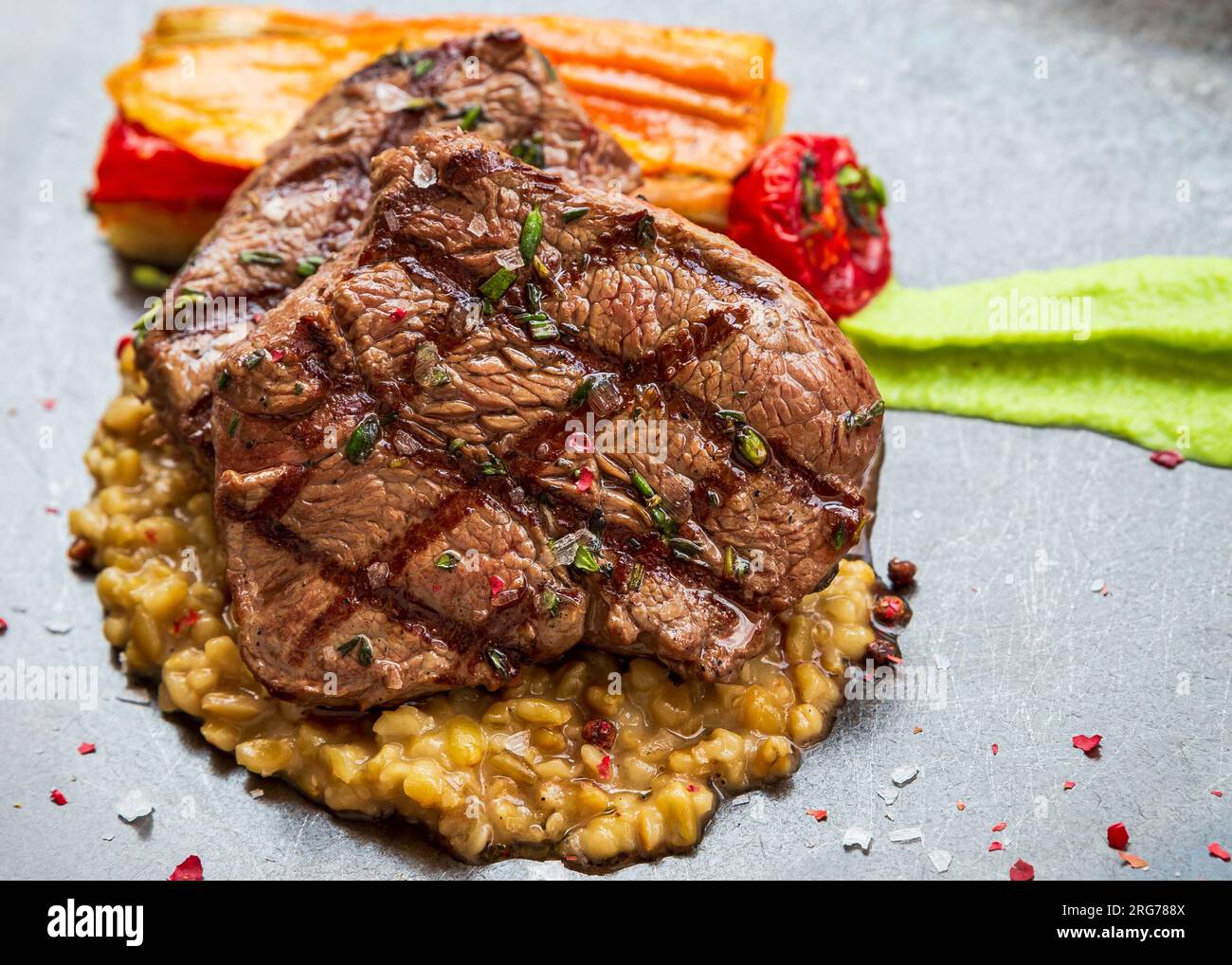 Grilled Beef Steak And Risotto. Beef steak with vegetables on a plate ...