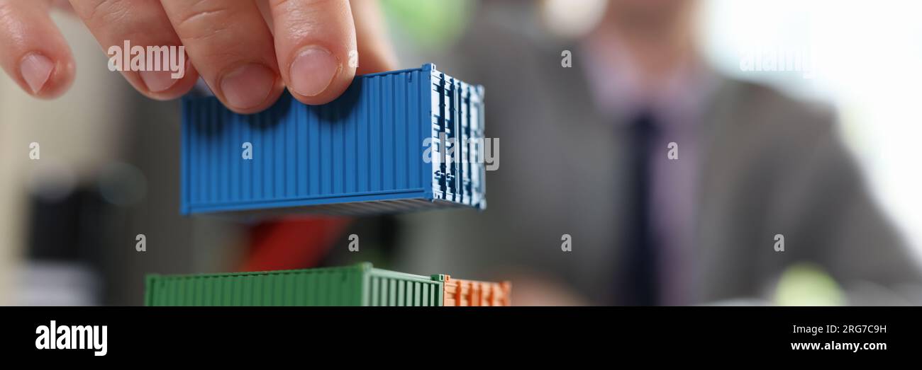 Business man arranging stack of freight cargo containers on office desk ...