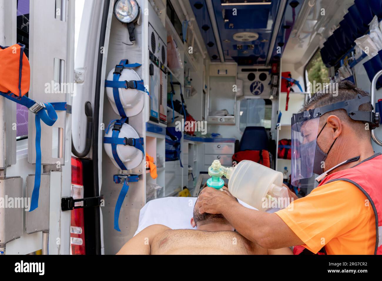 Lifeguard attending to an injured person with an oxygen tank and a ...