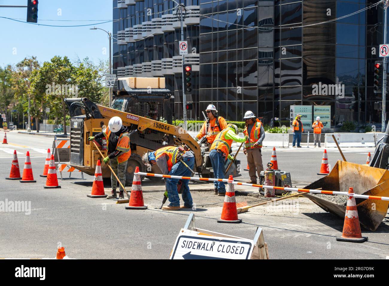 american road crew workers in hi viz repairing pavement surface in ...