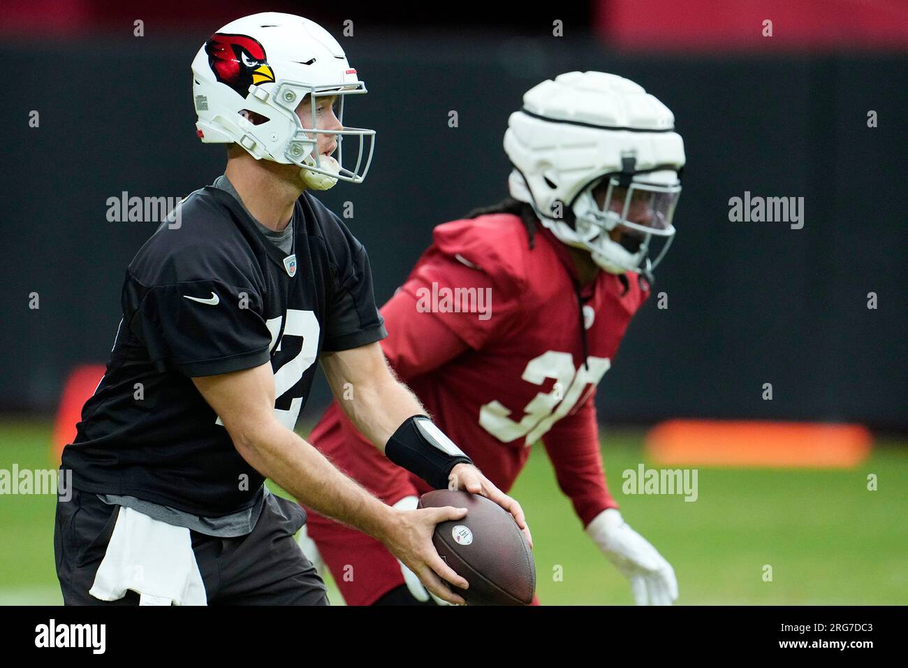 Arizona Cardinals quarterback Colt McCoy, left, pauses before handing ...
