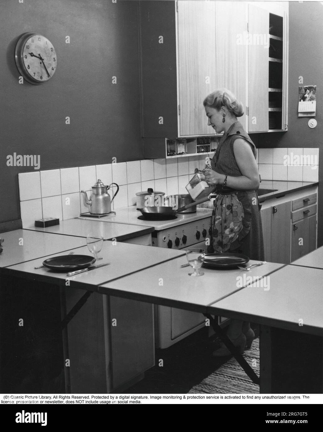 In the 1950s. A woman is seen at the electric cooker preparing a meal ...