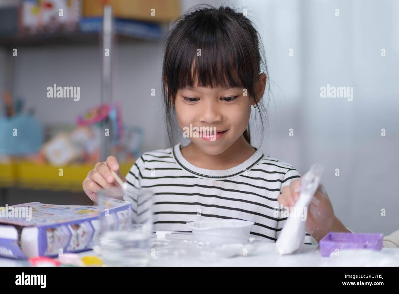 Cute little girl making DIY plaster and painting at home. Children ...