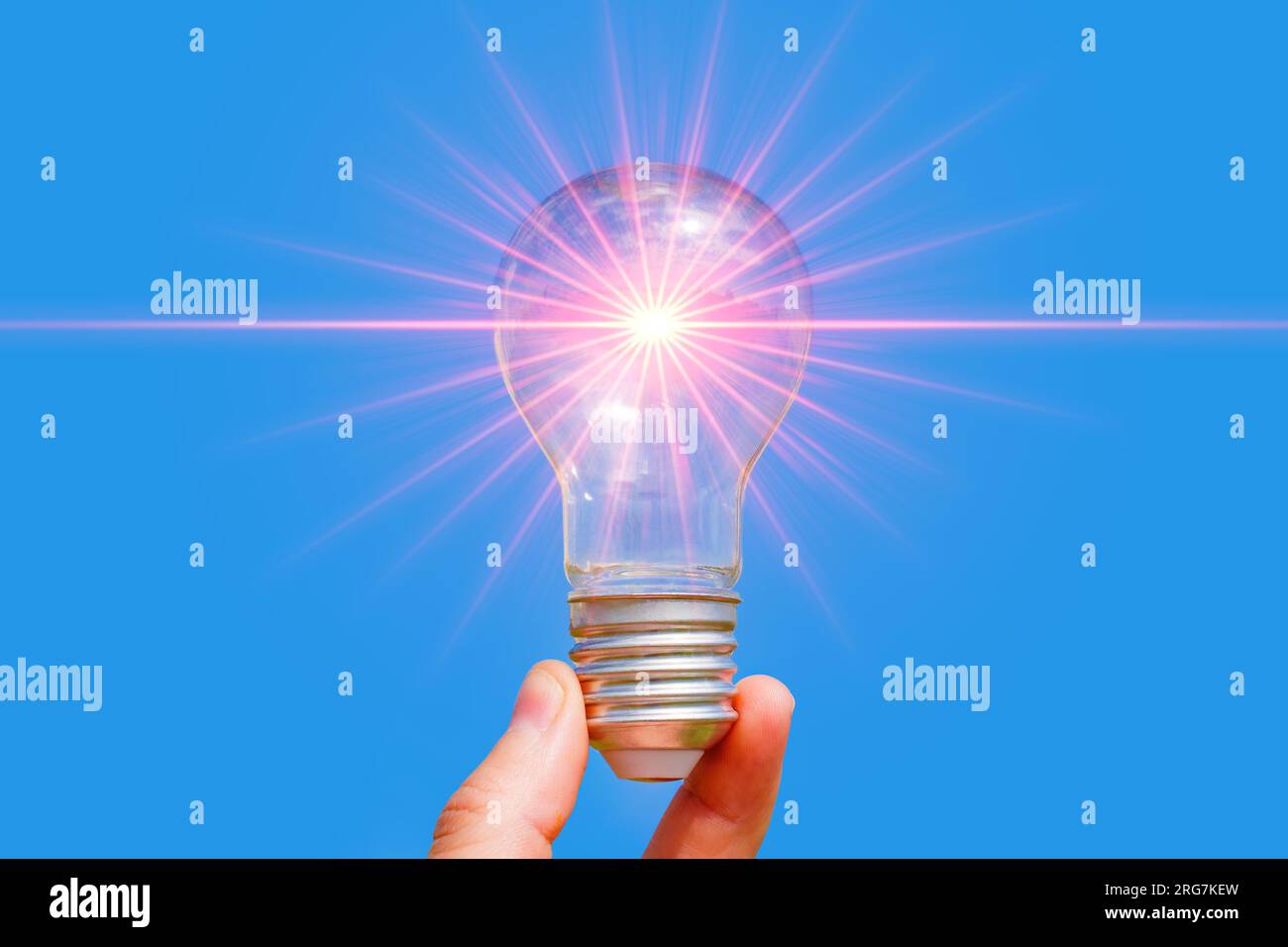 Glowing light bulb held in hand isolated on blue background. Innovation ...