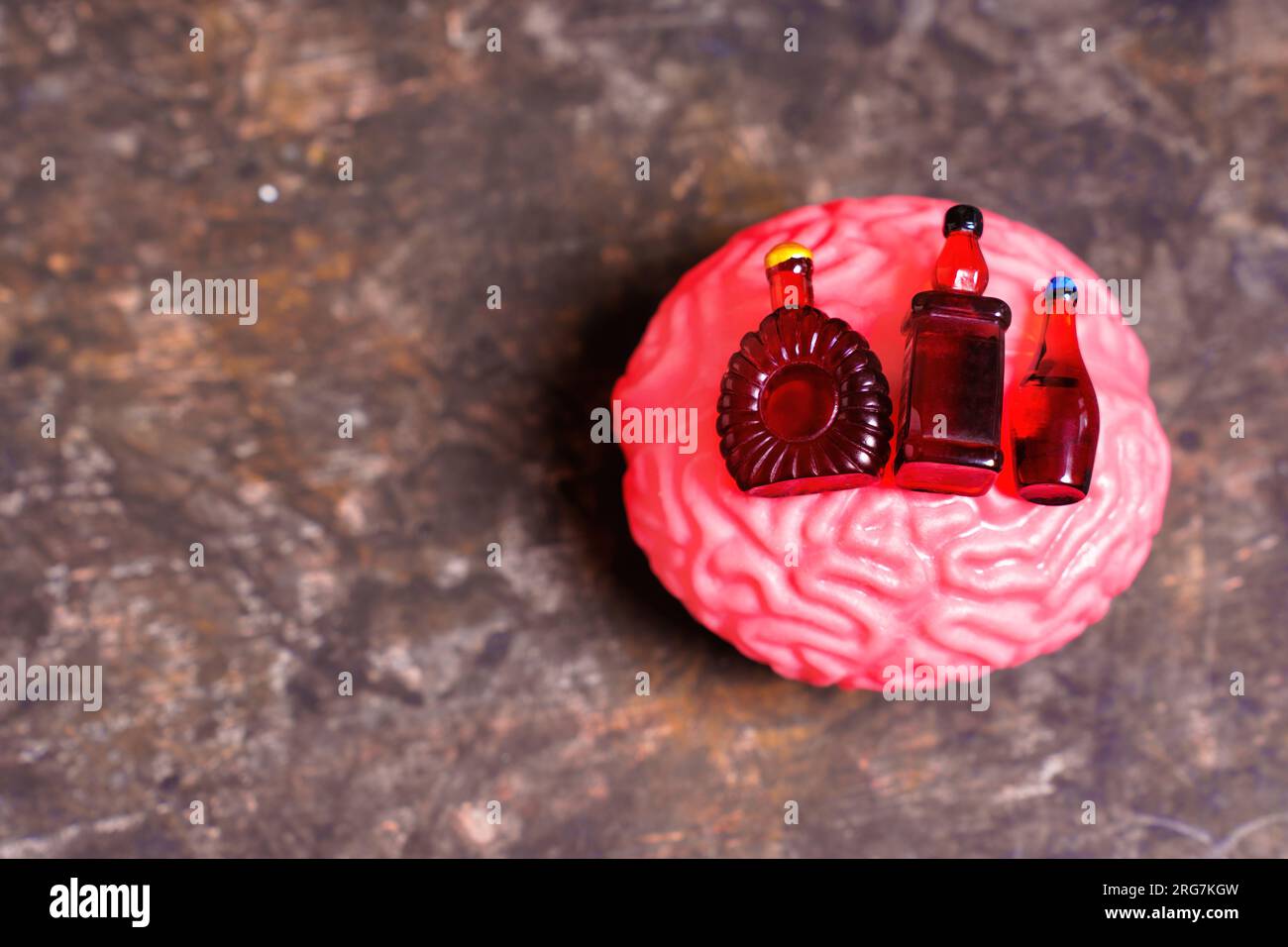 Liquor bottles arranged on top of a human brain model. Alcohol ...