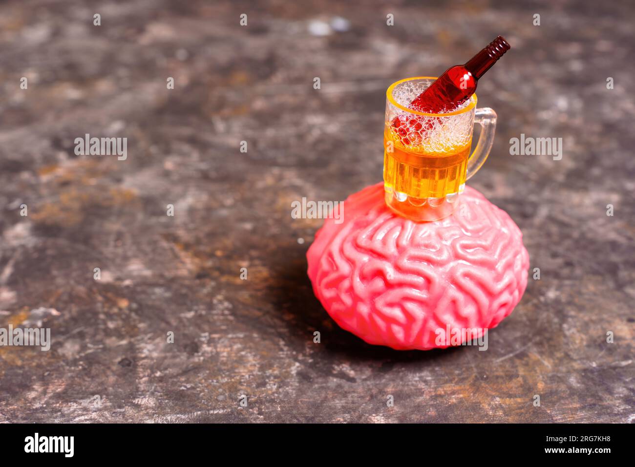 Miniature beer mug and beer bottle set on top of an anatomical model of ...