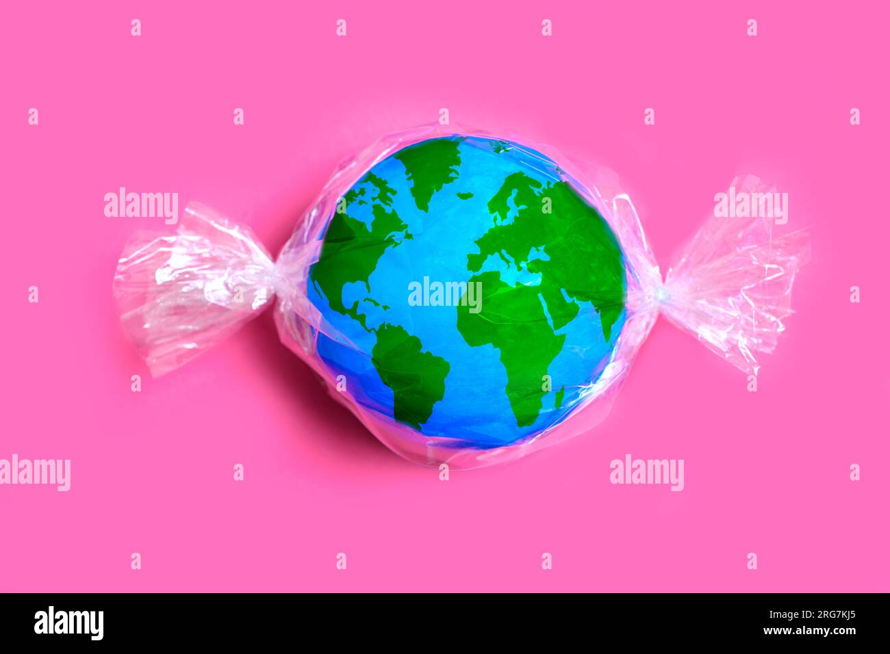 Miniature globe wrapped in plastic packaging like a candy, isolated on ...