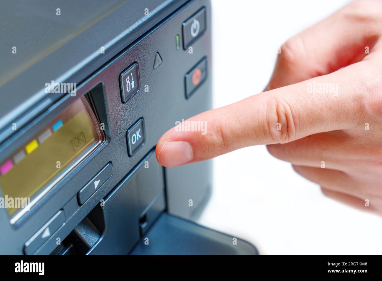 Close-up image capturing a finger pressing the 'OK' button on a printer ...