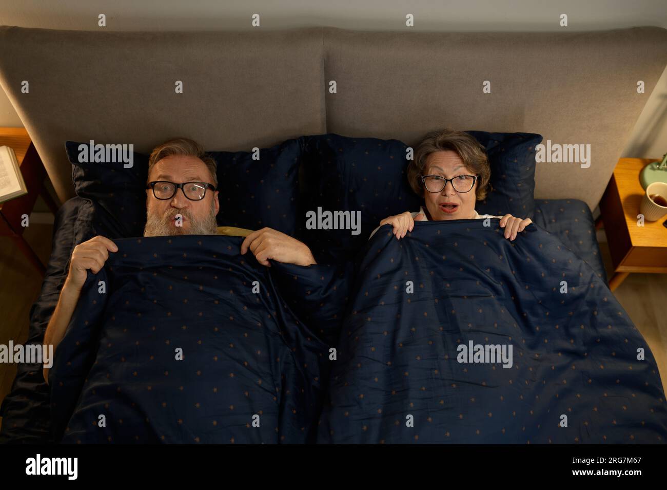 Overhead view of screaming scared old couple in bed Stock Photo - Alamy