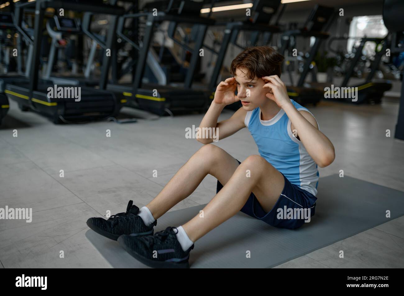 Fitness teenage boy exercising doing crunches for abs muscles building ...