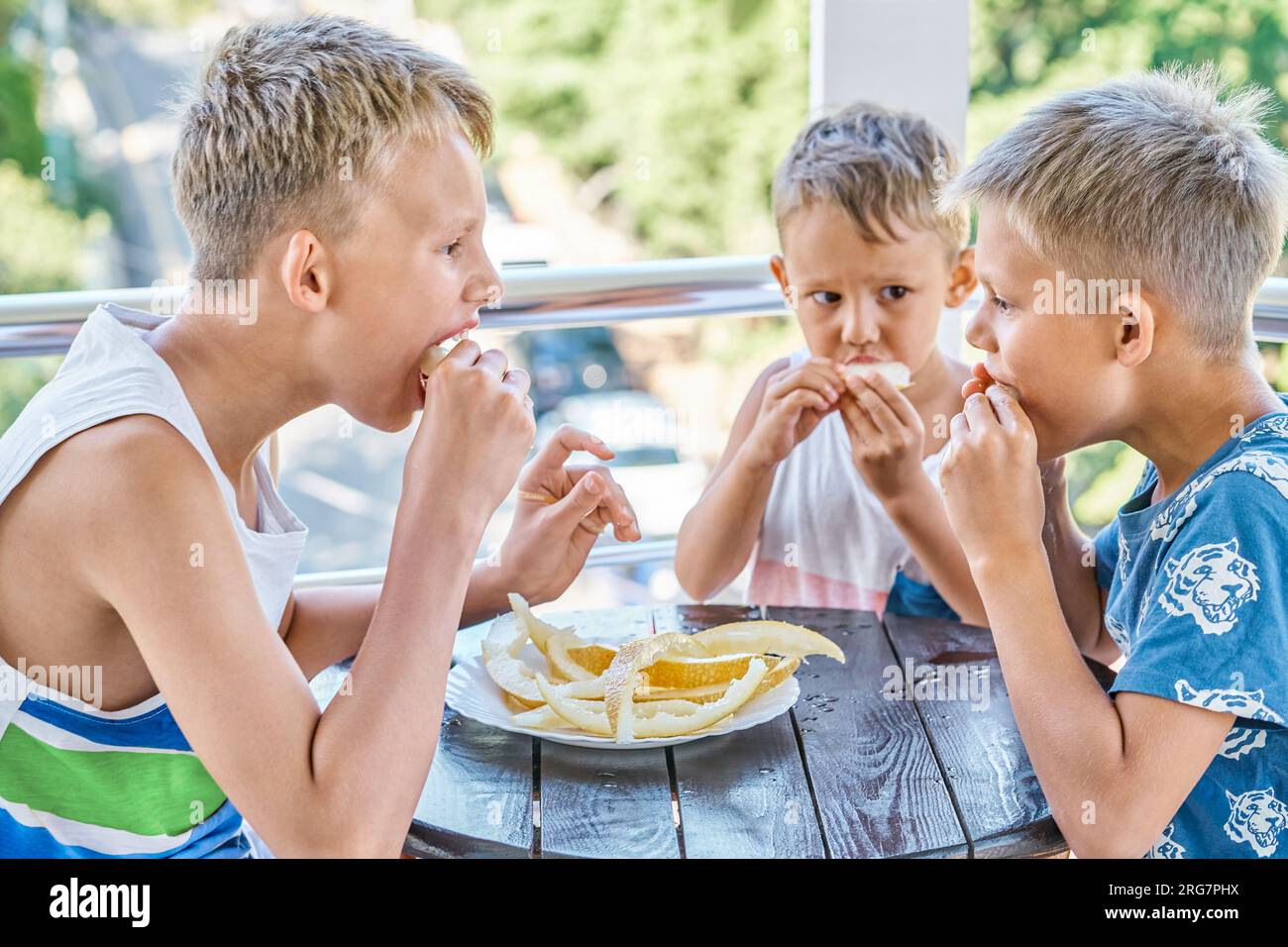 Junior school children and preschooler boy eating fresh melon on hotel ...