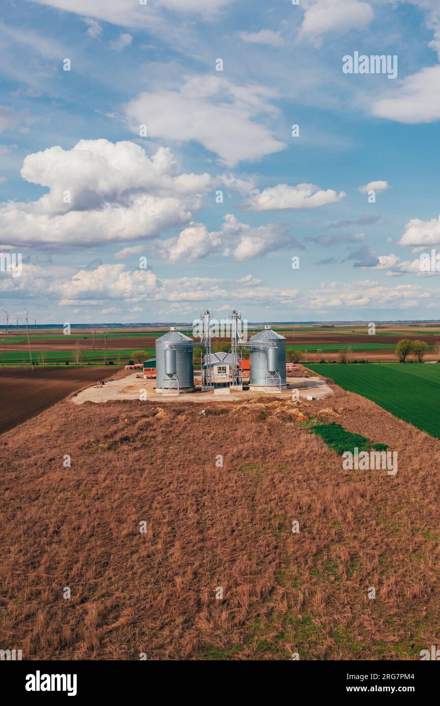 Farm silos in field, aerial view from drone pov on sunny spring day ...
