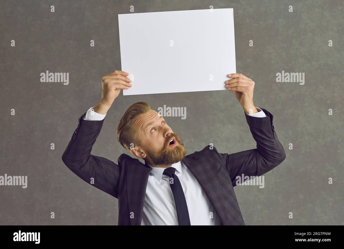 Studio portrait of adult caucasian businessman holding overhead blank ...