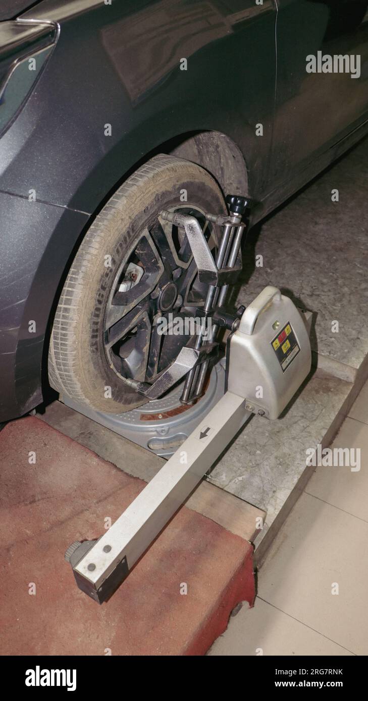a car tire under maintenance and correction of steering camber, caster ...