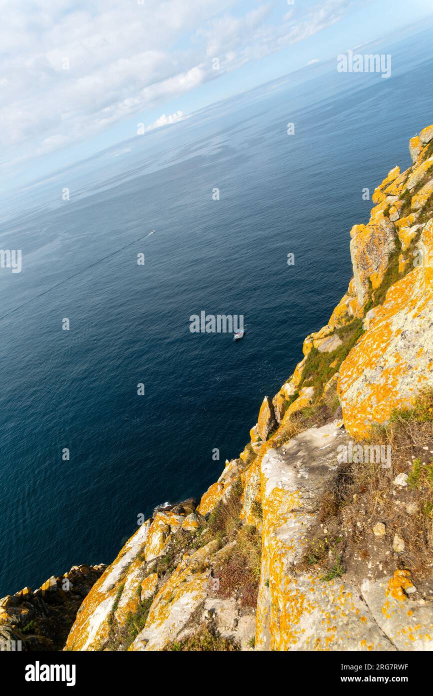Fishing trawler boat far below steep cliffs Isla del Faro, Cies Islands ...