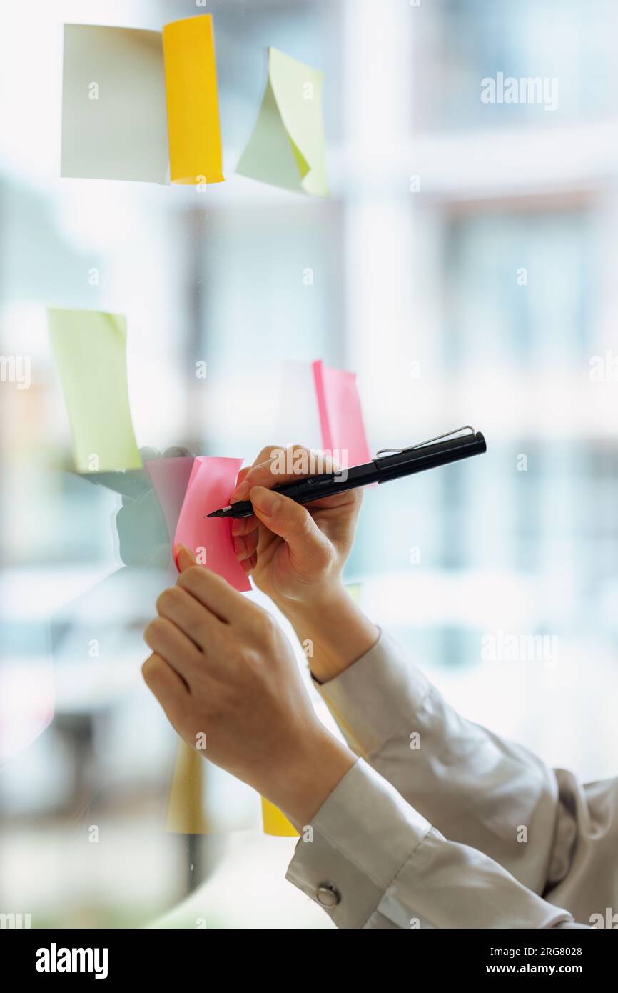 Through glass view of businesswoman analyzing process schedule ...