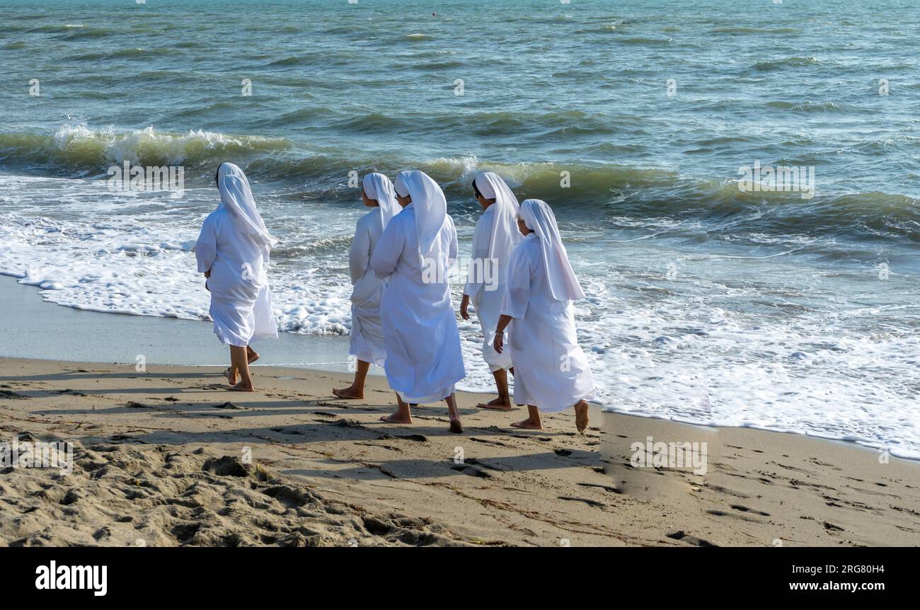 Nuns walk in the sand on the italia beach Stock Photo - Alamy