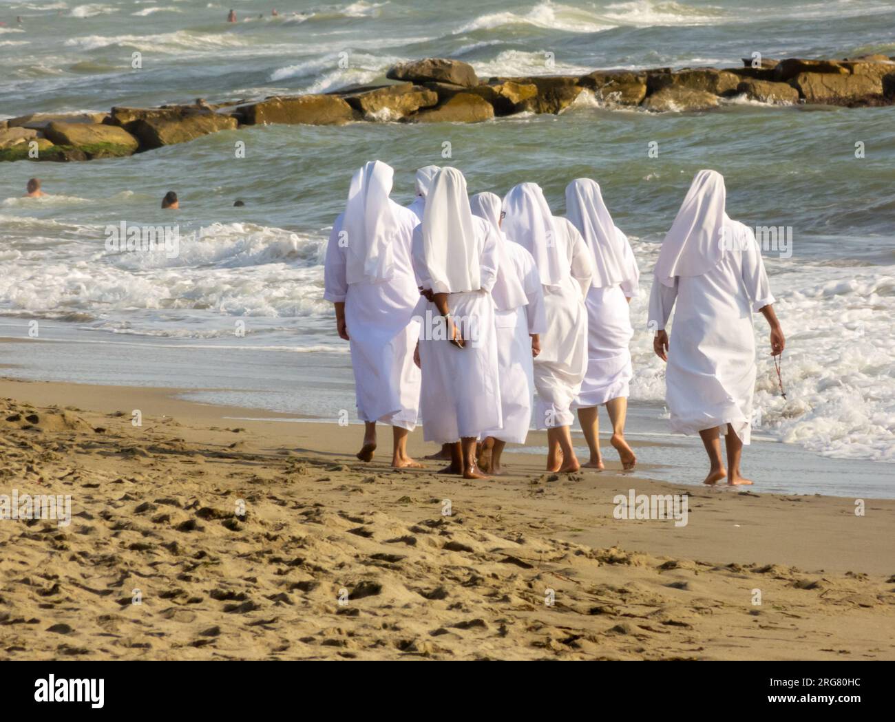Nuns walk in the sand on the italia beach Stock Photo - Alamy