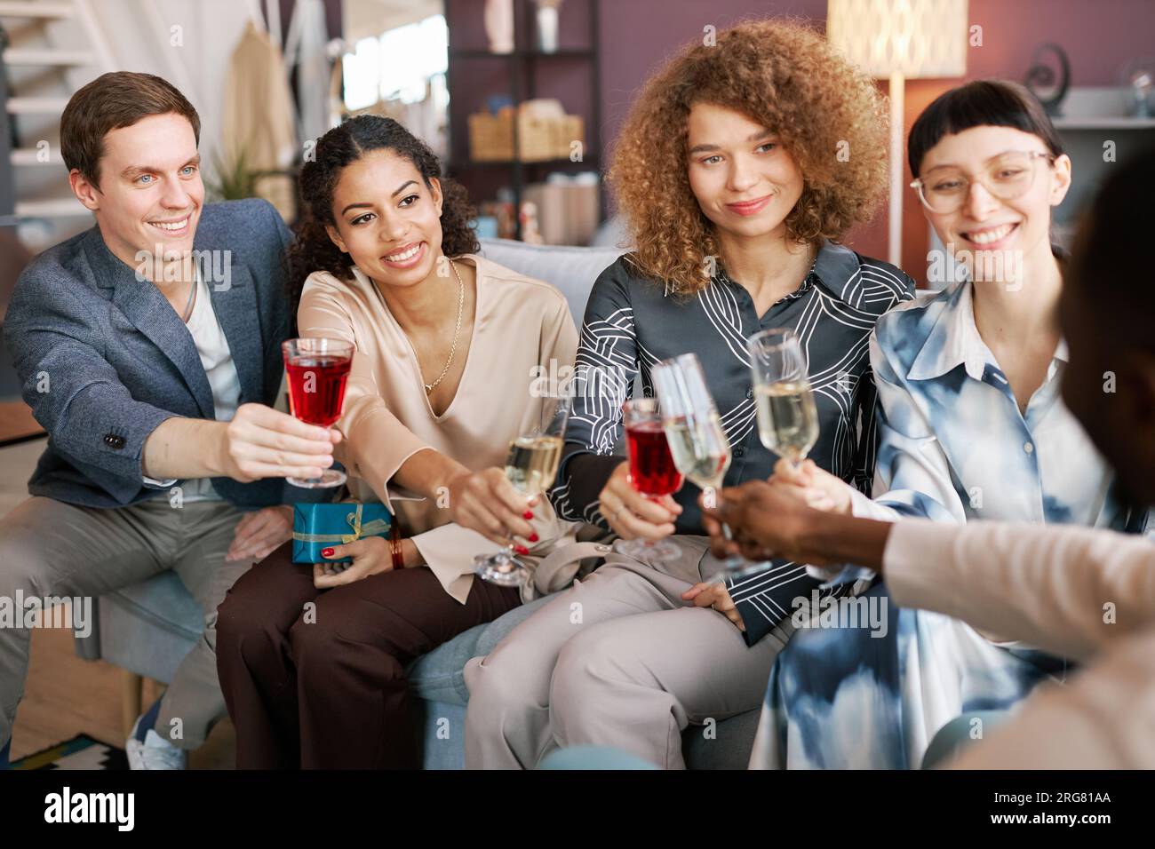 Row of happy intercultural girls and guy with glasses of alcoholic ...
