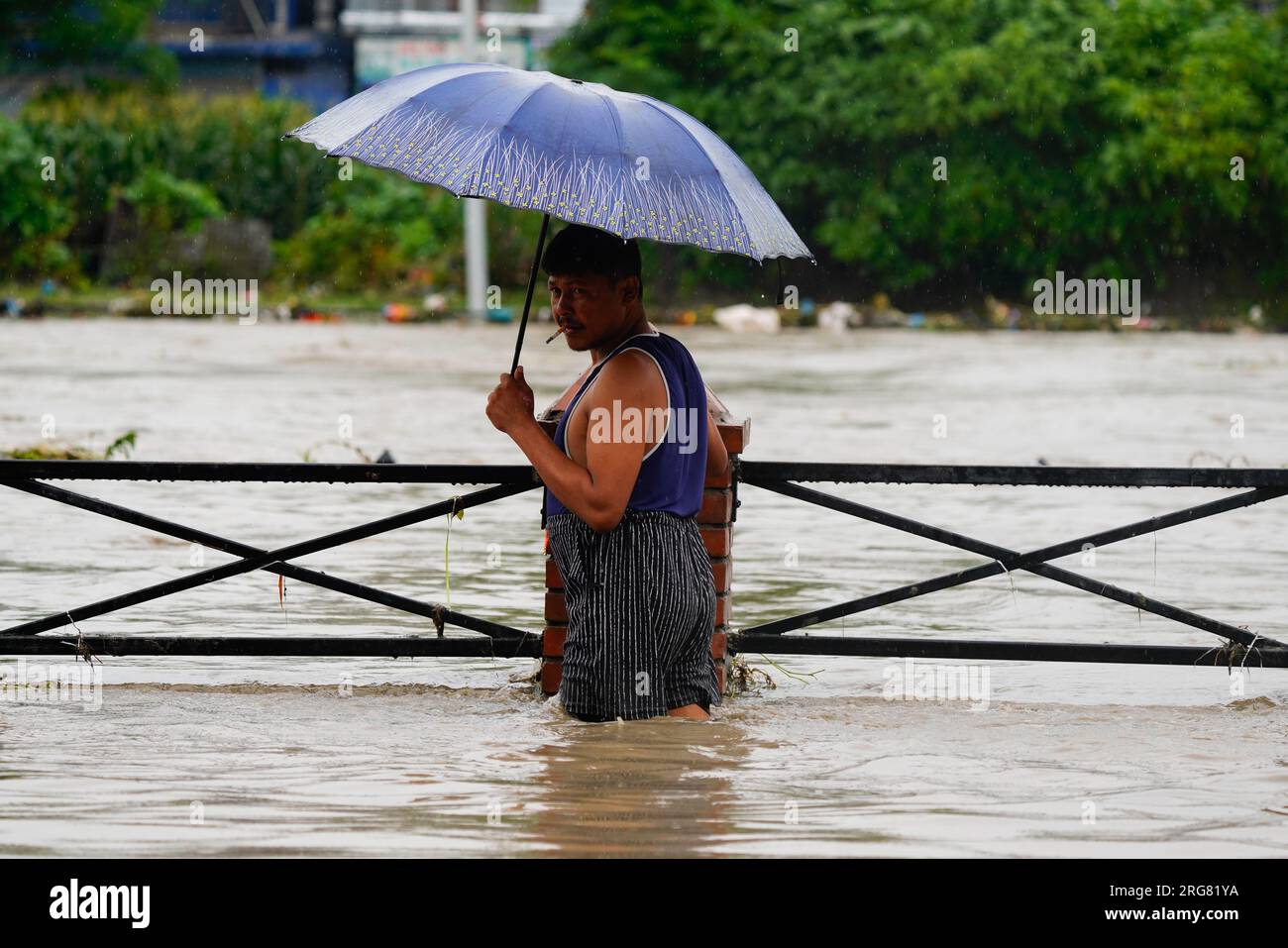 Kathmandu, Nepal. 08th Aug, 2023. A man wades through flooded homes ...