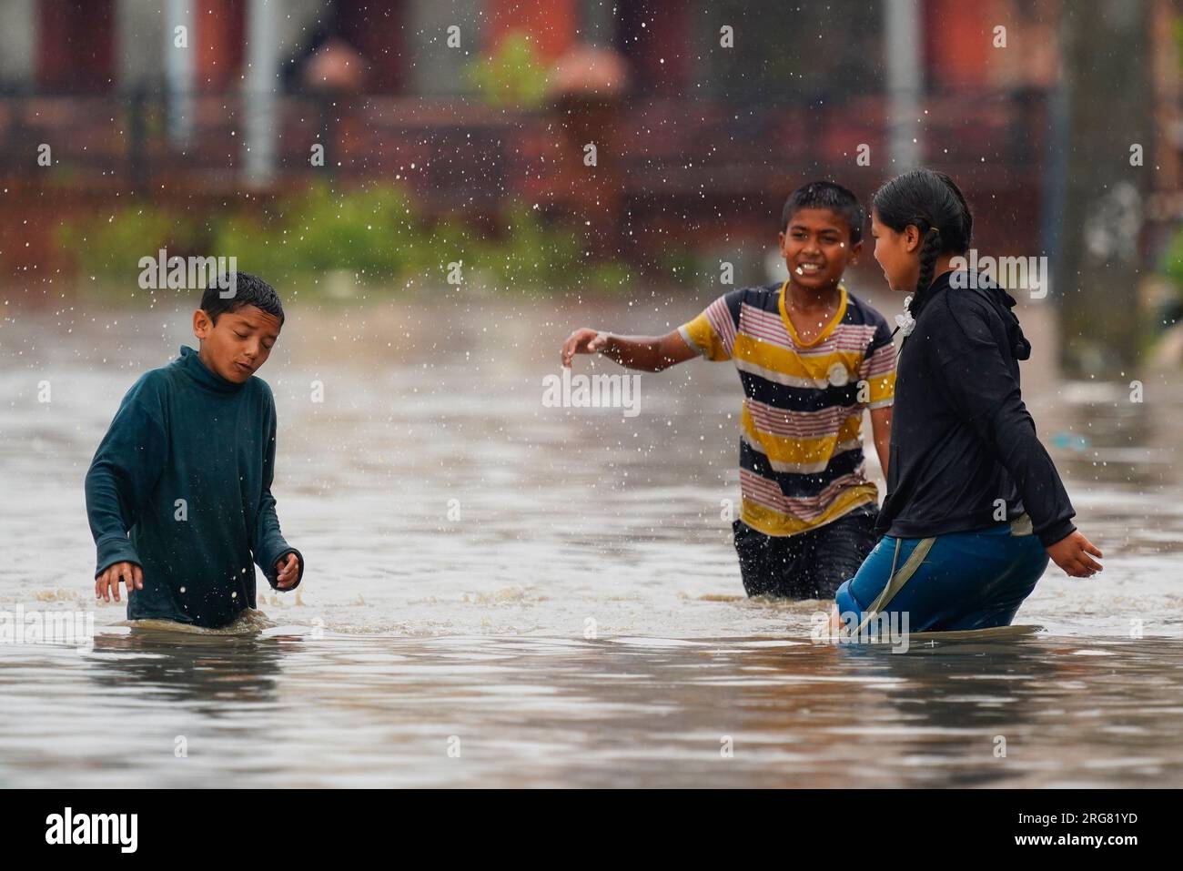 Kathmandu, Nepal. 08th Aug, 2023. Children play on a flooded area outside their homes after ...