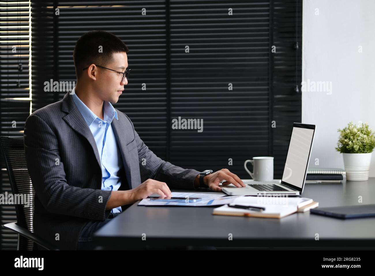 Focused millennial male economist analyzing sales statistics on laptop ...