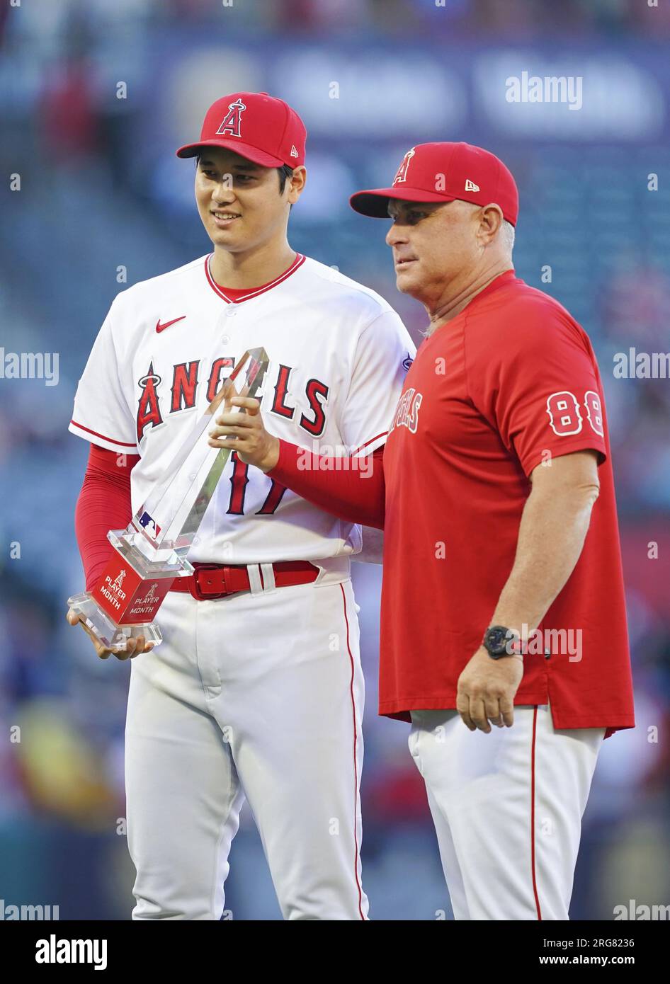 Shohei Ohtani of the Los Angeles Angels holds a trophy, alongside team ...