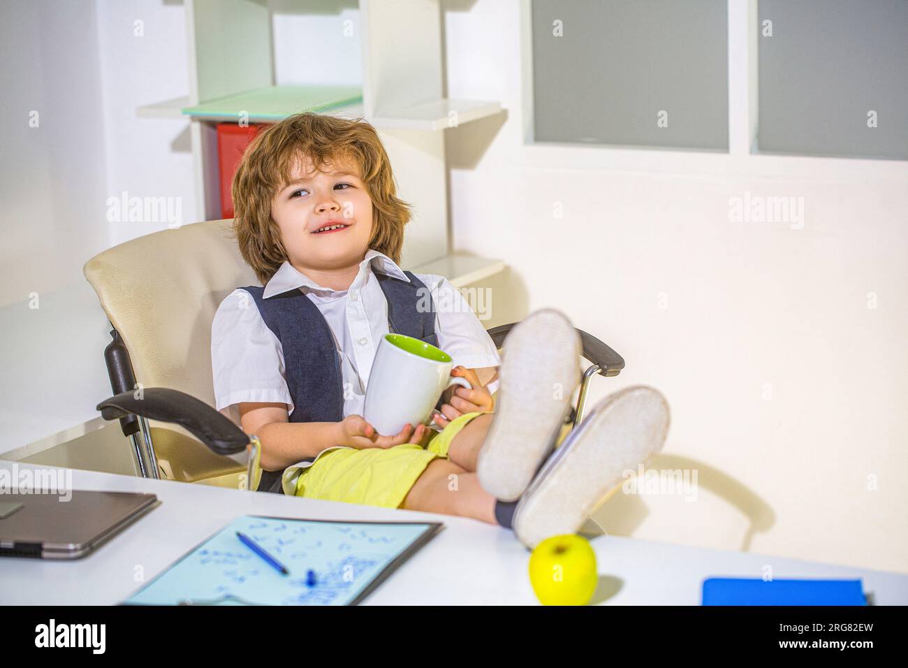 Male child playing business, holding a cup in his hands, riding on an ...