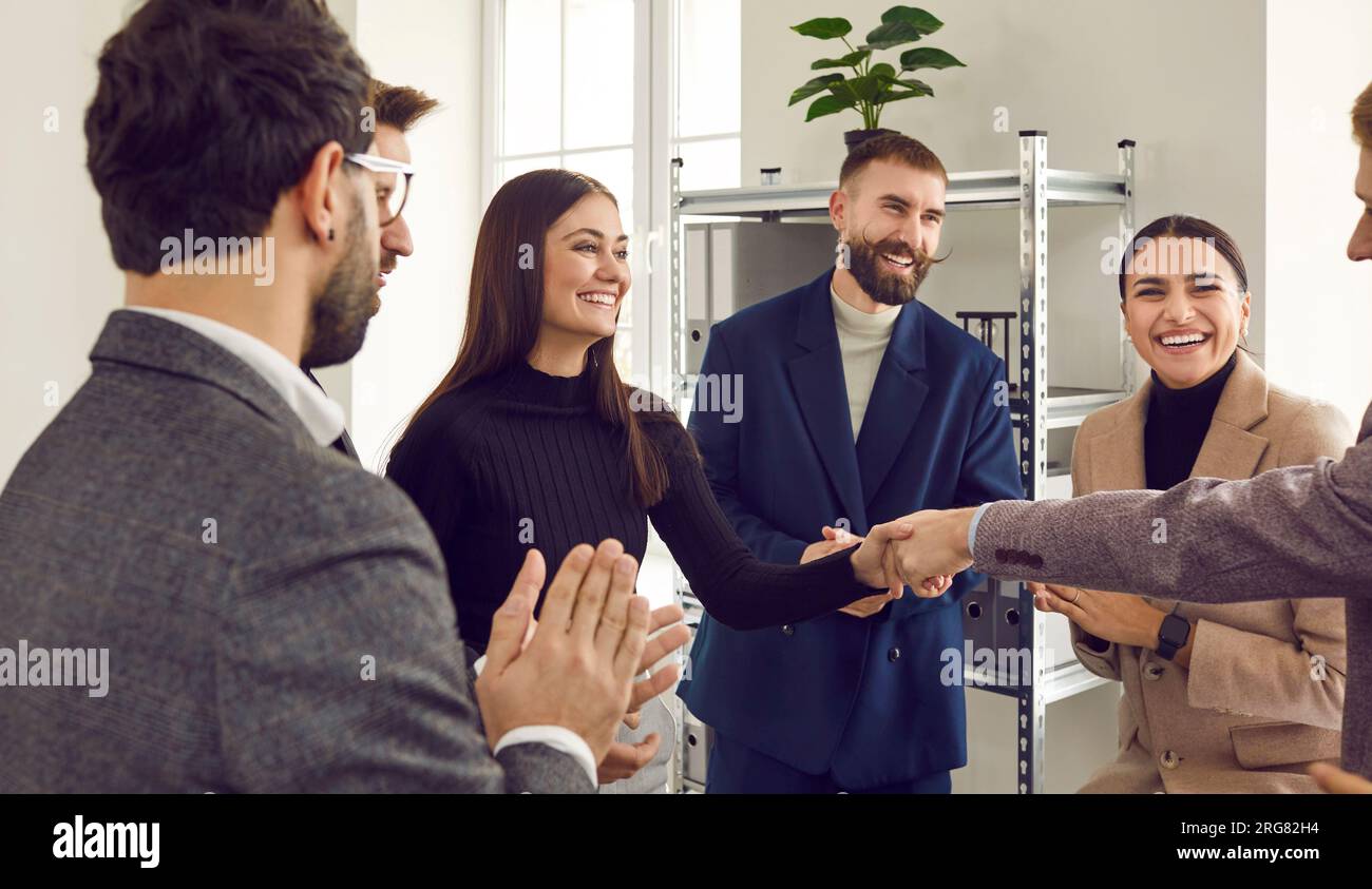 Joyful business people in office greet each other with handshake to ...