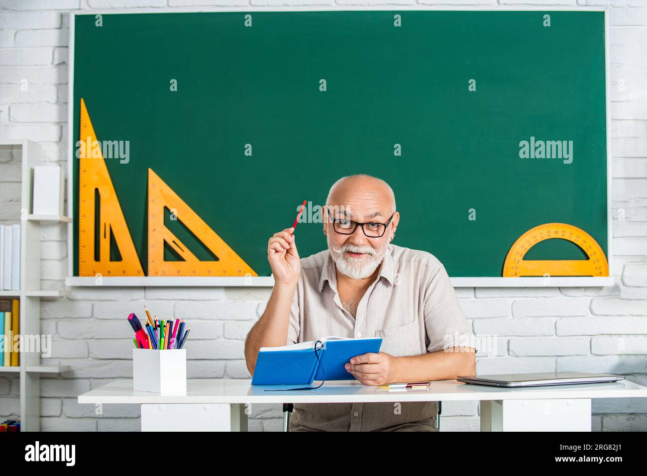 Portrait male teacher in classroom. Man elementary school teacher ...