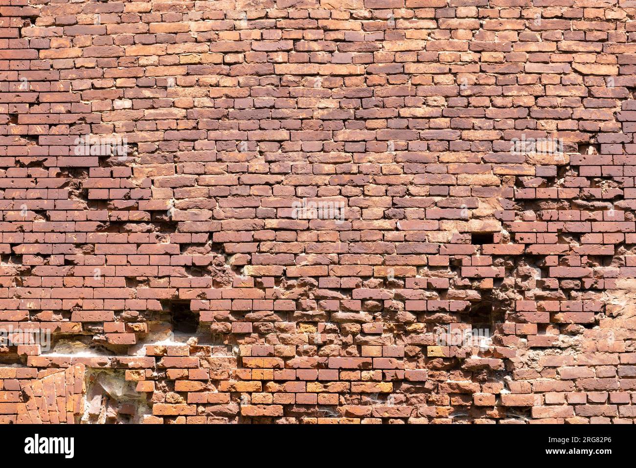 An old brick wall with various damages, the wall is old and made of ...