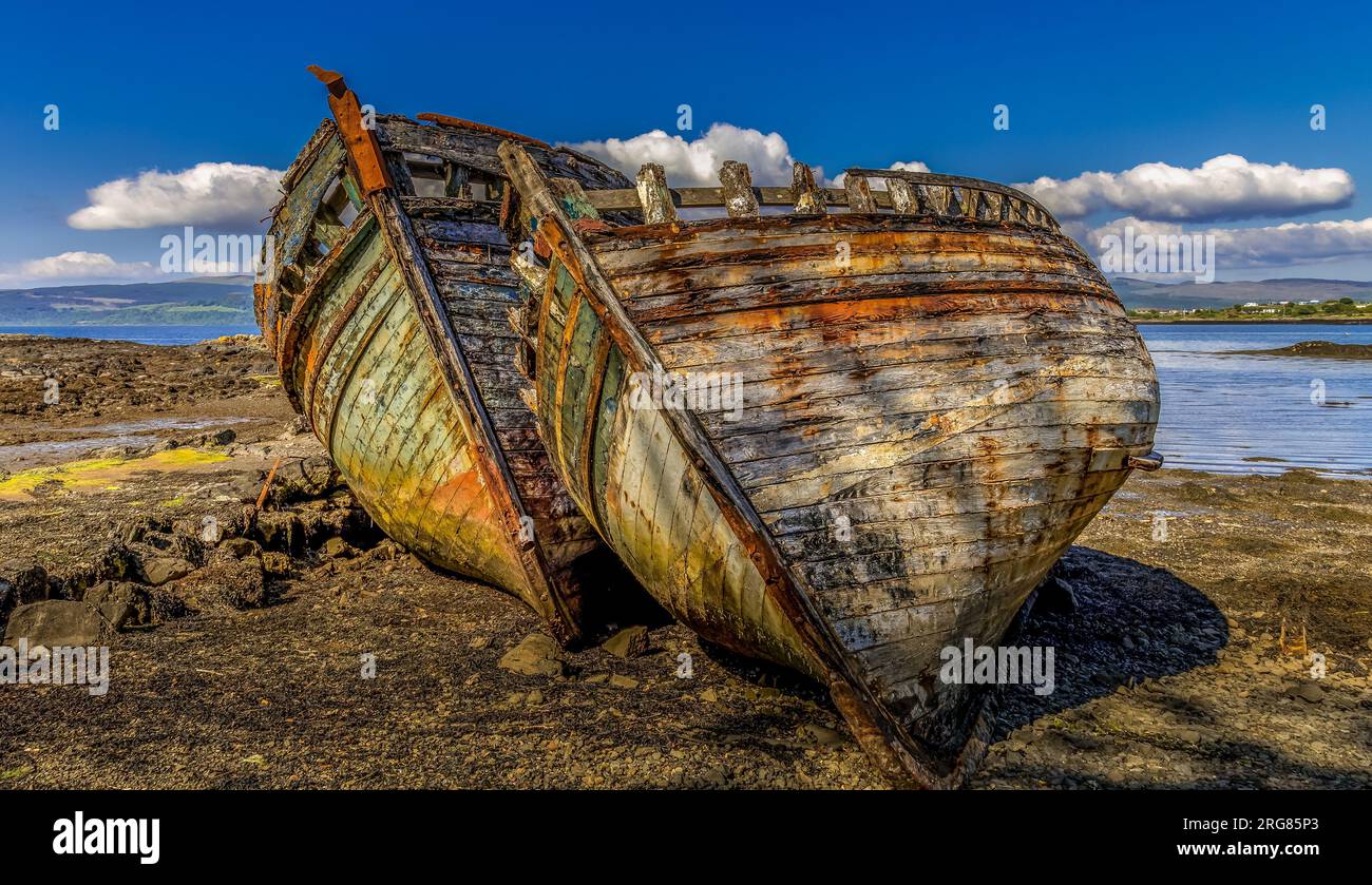 Old wooden fishing boats wrecked at the side of the sea, Isle of Mull ...