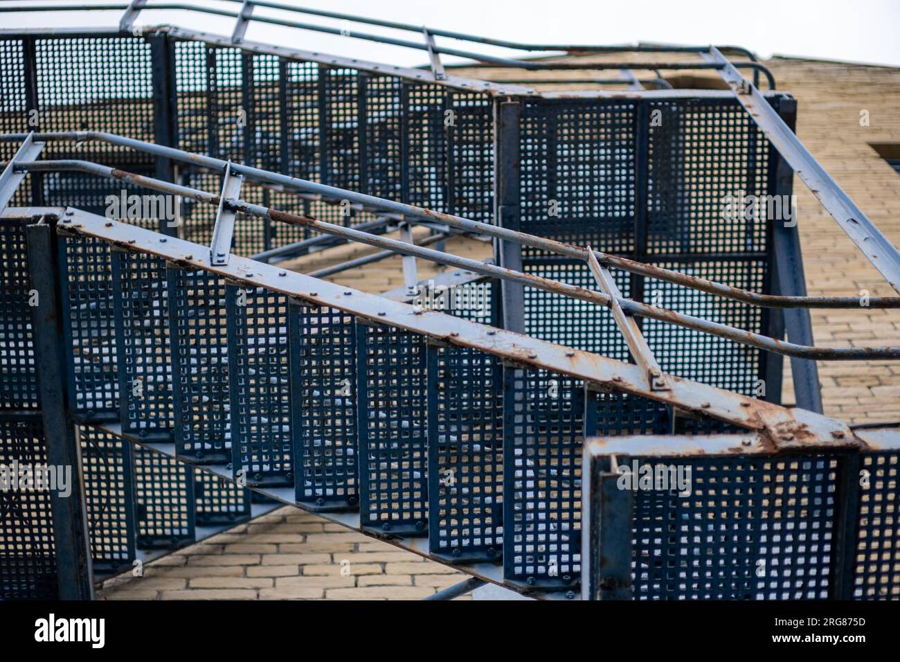 Close up on blue metal fire escape steps on outside of old warehouse ...