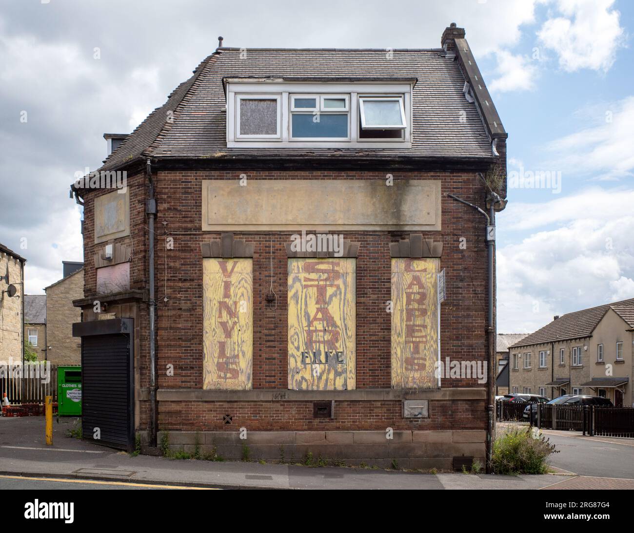 Boarded up building, a carpet business shut down, stands alone in ...