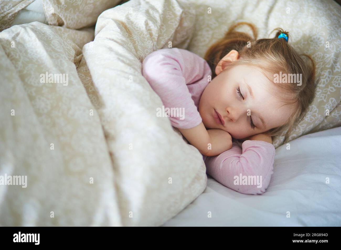 Adorable preschooler girl having a day nap. Little child sleeping in bed. Bedtime concept Stock ...