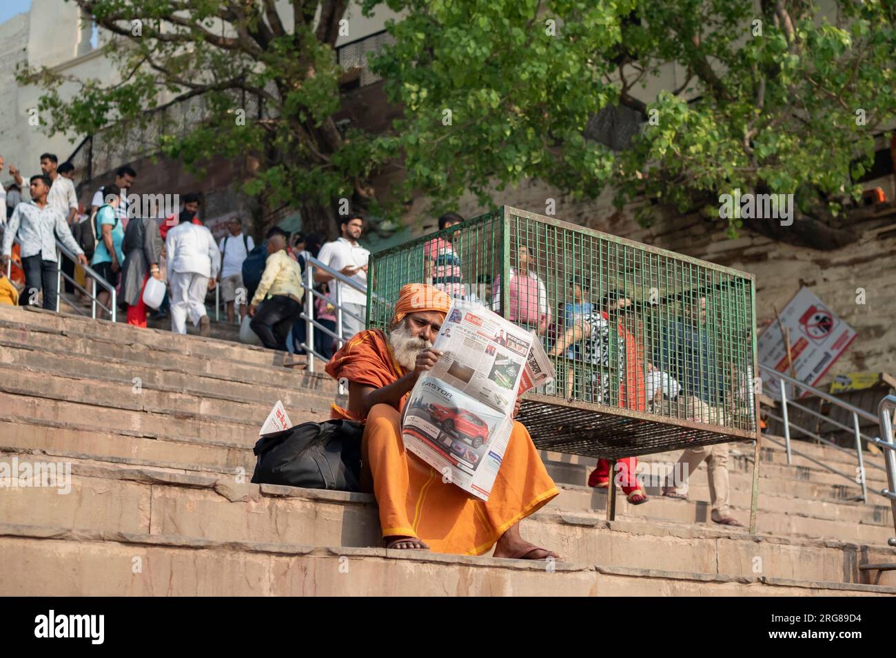 Varanasi India - March 13 2023 Monk reading newspaper on Dashashvamedh ...