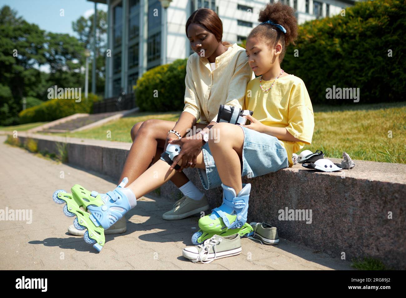 African American mom helping her child to put on protection before ...