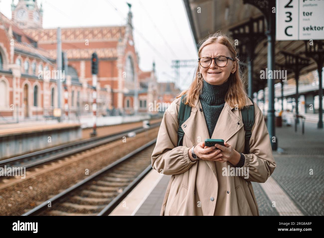 Young unhappy lost woman crying and waiting train on station platform ...