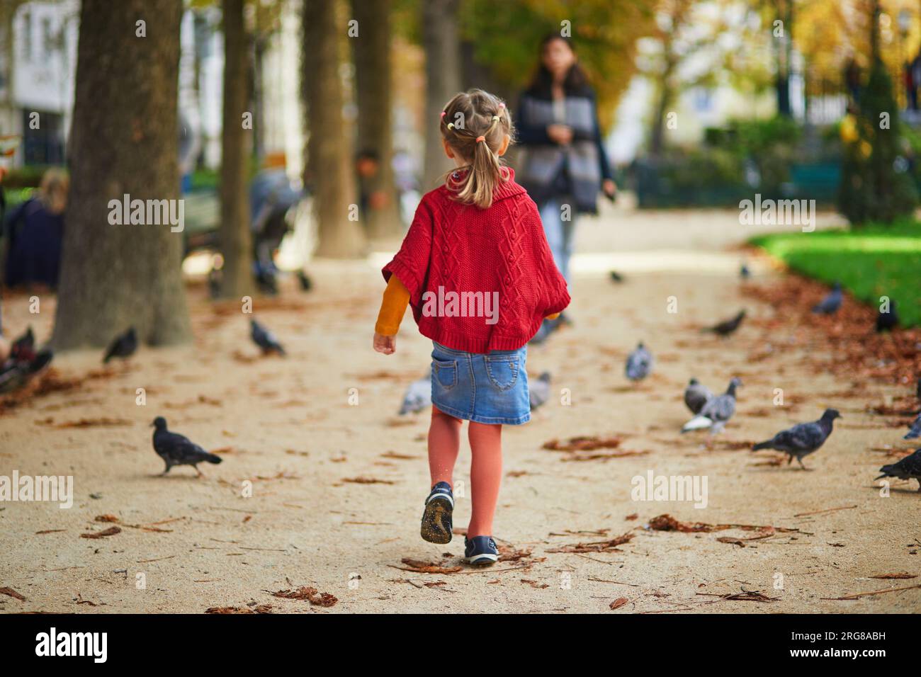 Adorable preschooler girl enjoying nice and sunny autumn day outdoors ...