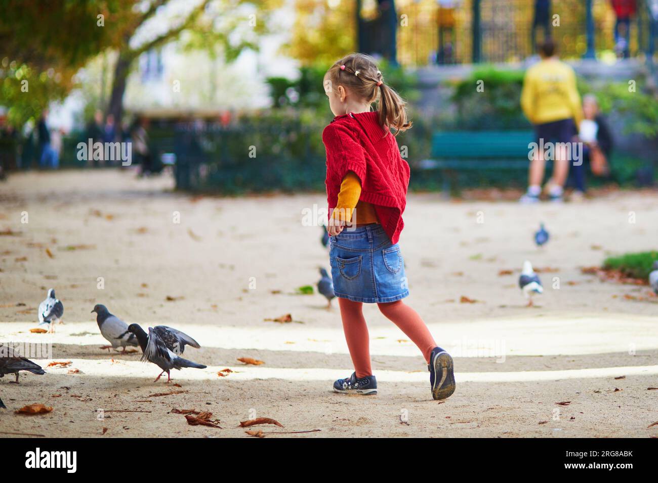 Adorable preschooler girl enjoying nice and sunny autumn day outdoors ...