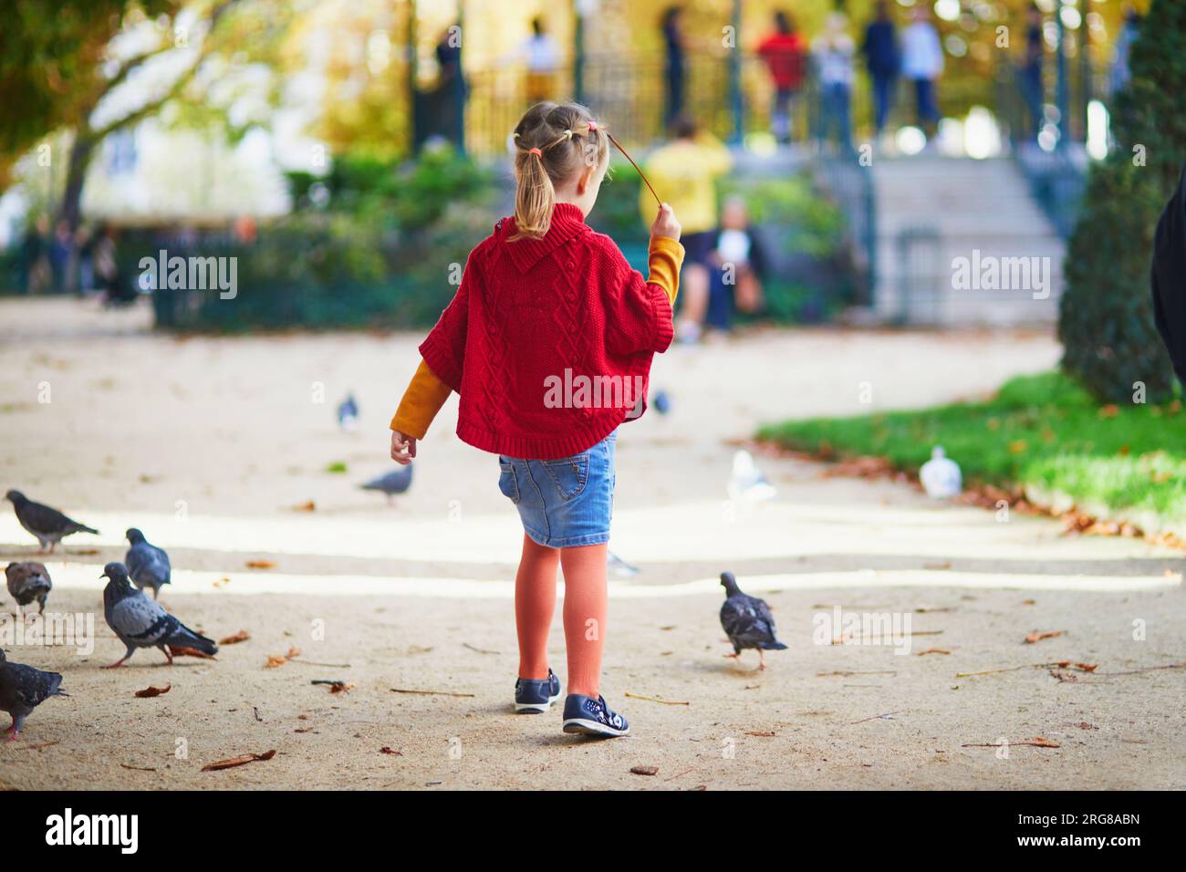 Adorable preschooler girl enjoying nice and sunny autumn day outdoors ...
